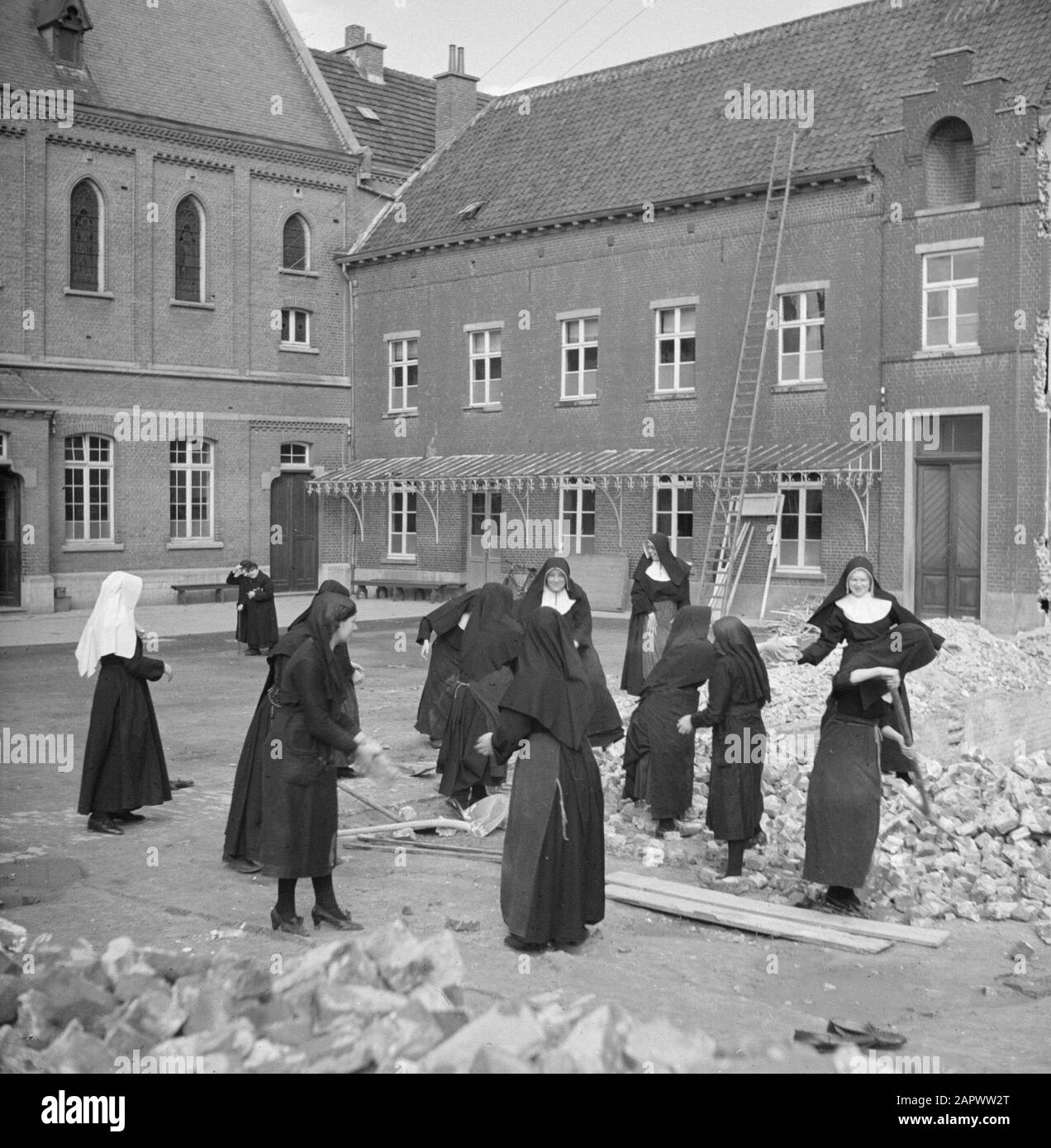 Rebuilding of a nunnery Nuns in courtyard engaged in construction ...