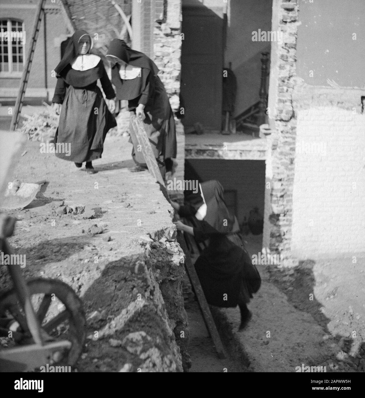 Rebuilding of a nunnery Nuns on ladder against embankment of cellar ...