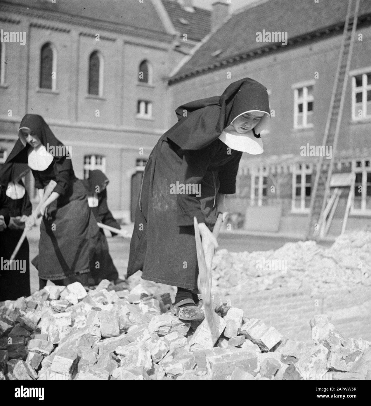 Rebuilding a nunnery Nuns working with picks Date: 1940 Location ...