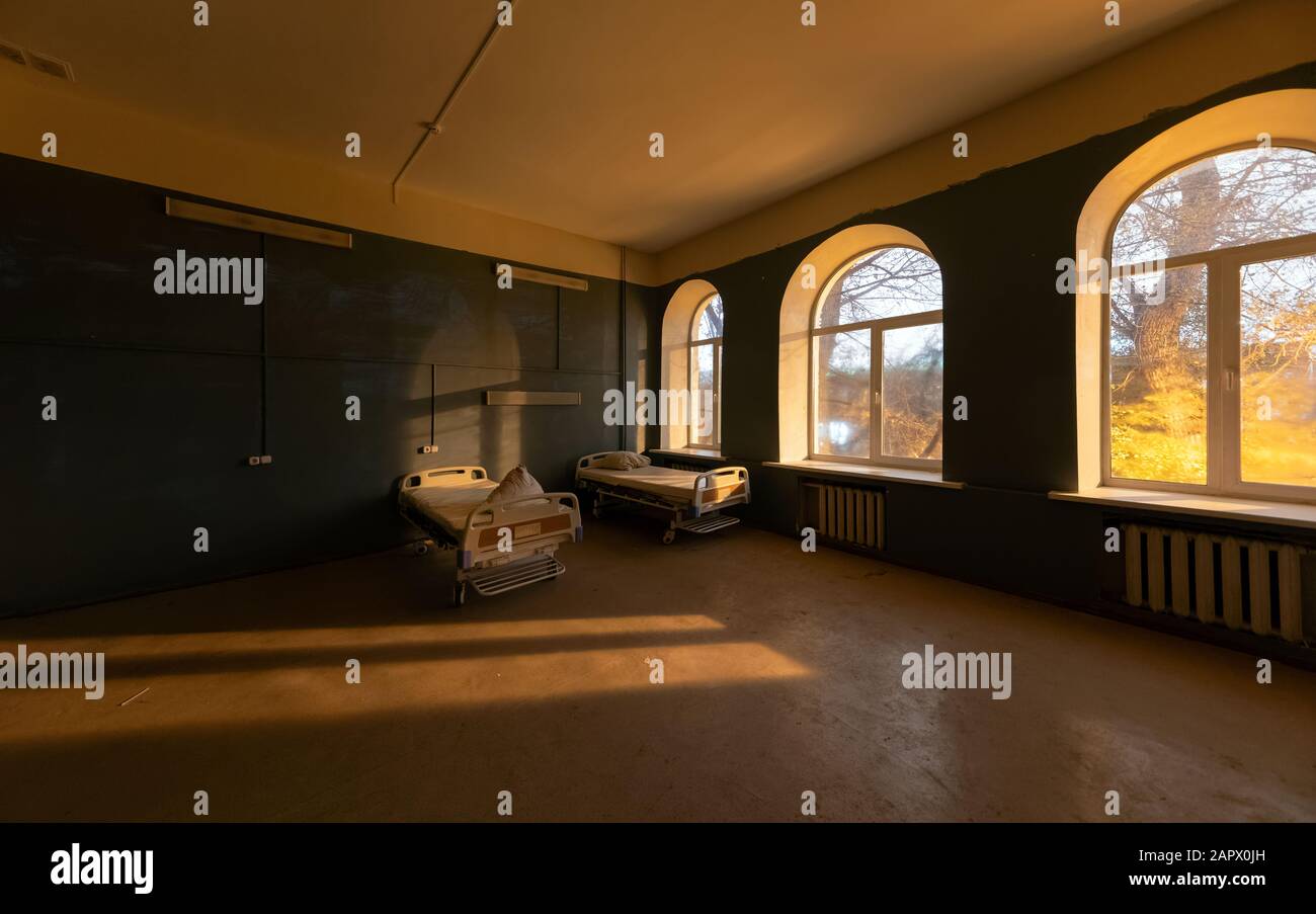 Hospital ward with large semicircular windows and beds, in an abandoned ...