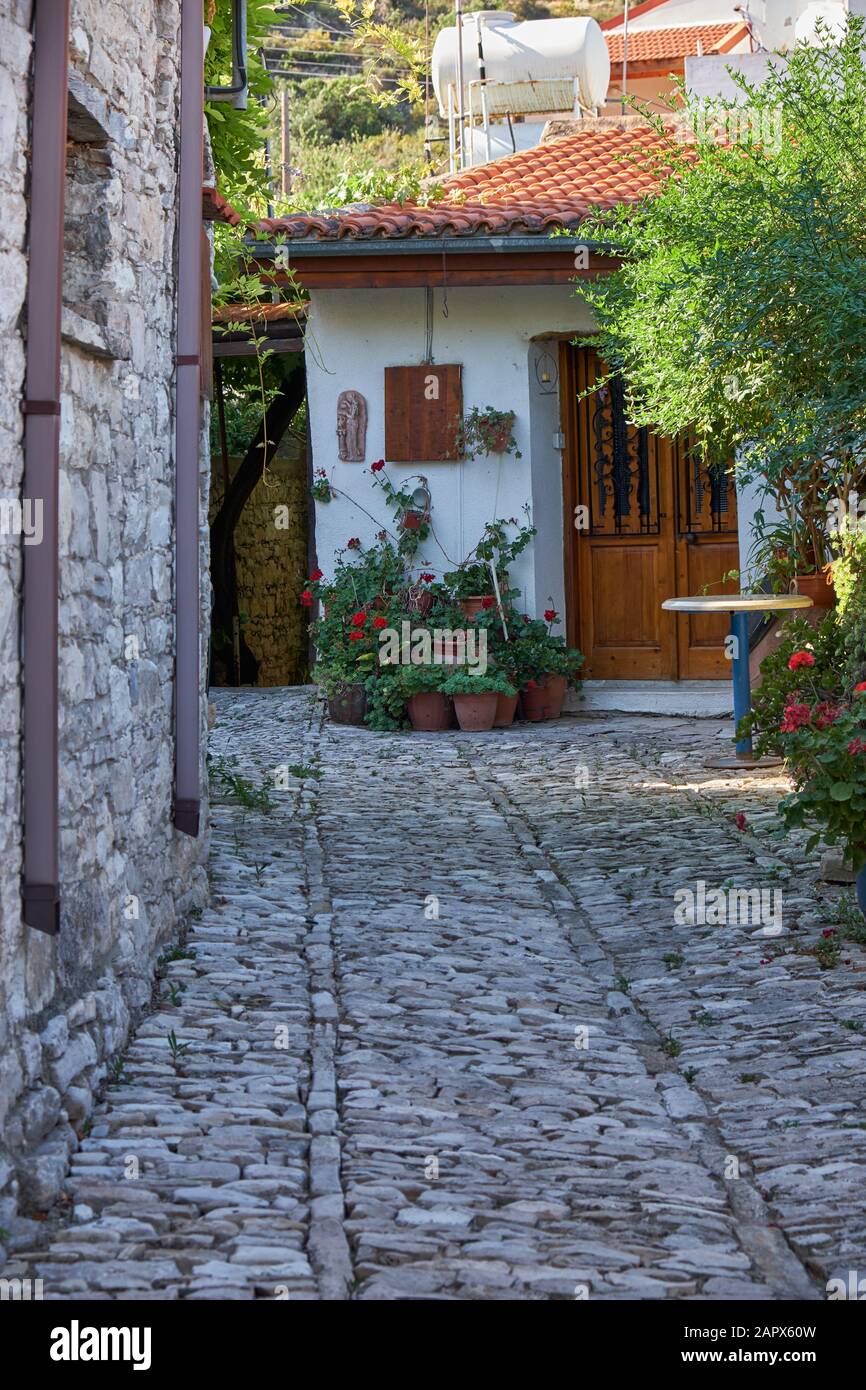 The view of the narrow flower-lined stone paved street of the Lania ...
