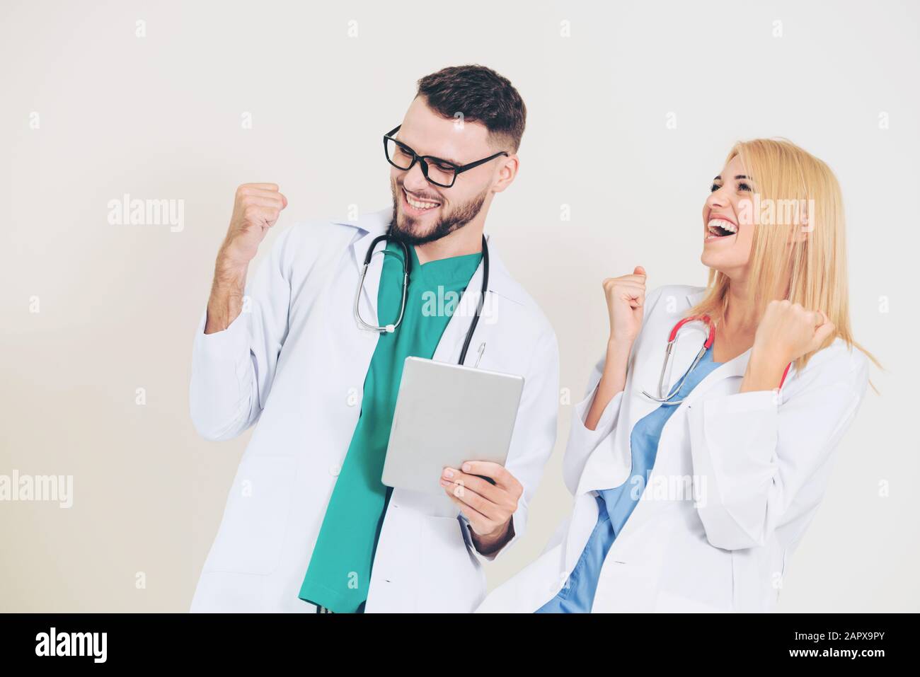 Happy young doctors celebrate success on white background. Medical ...