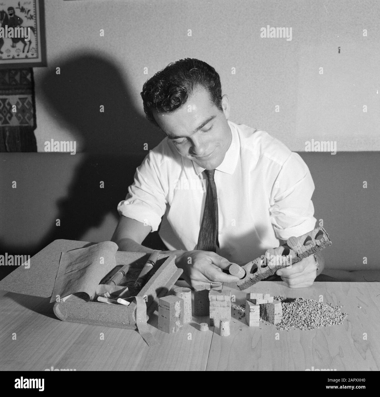 Adult man plays with cork. Next to him cigars in a cigar box ...