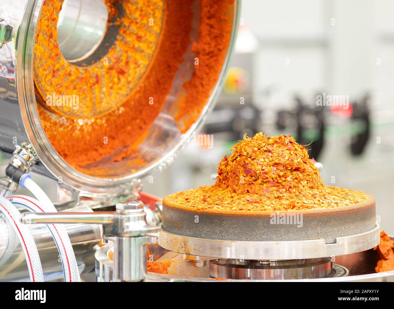 Fine red ground chili in chili paste grinder machine ; industrial food ...