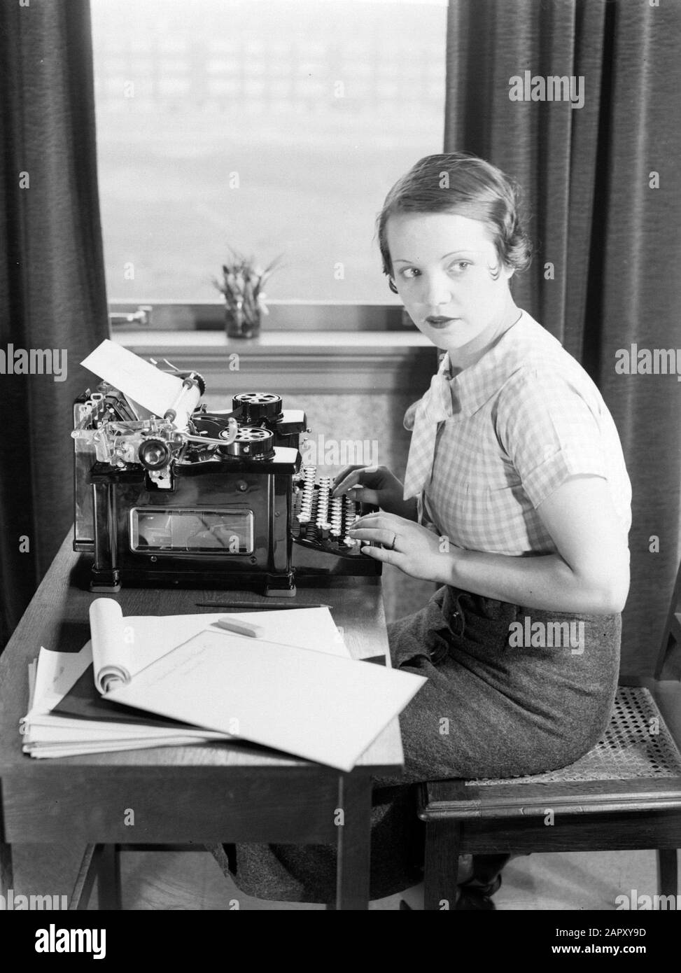 Woman behind a typewriter with a block Date: 1931 Keywords: typewriters ...