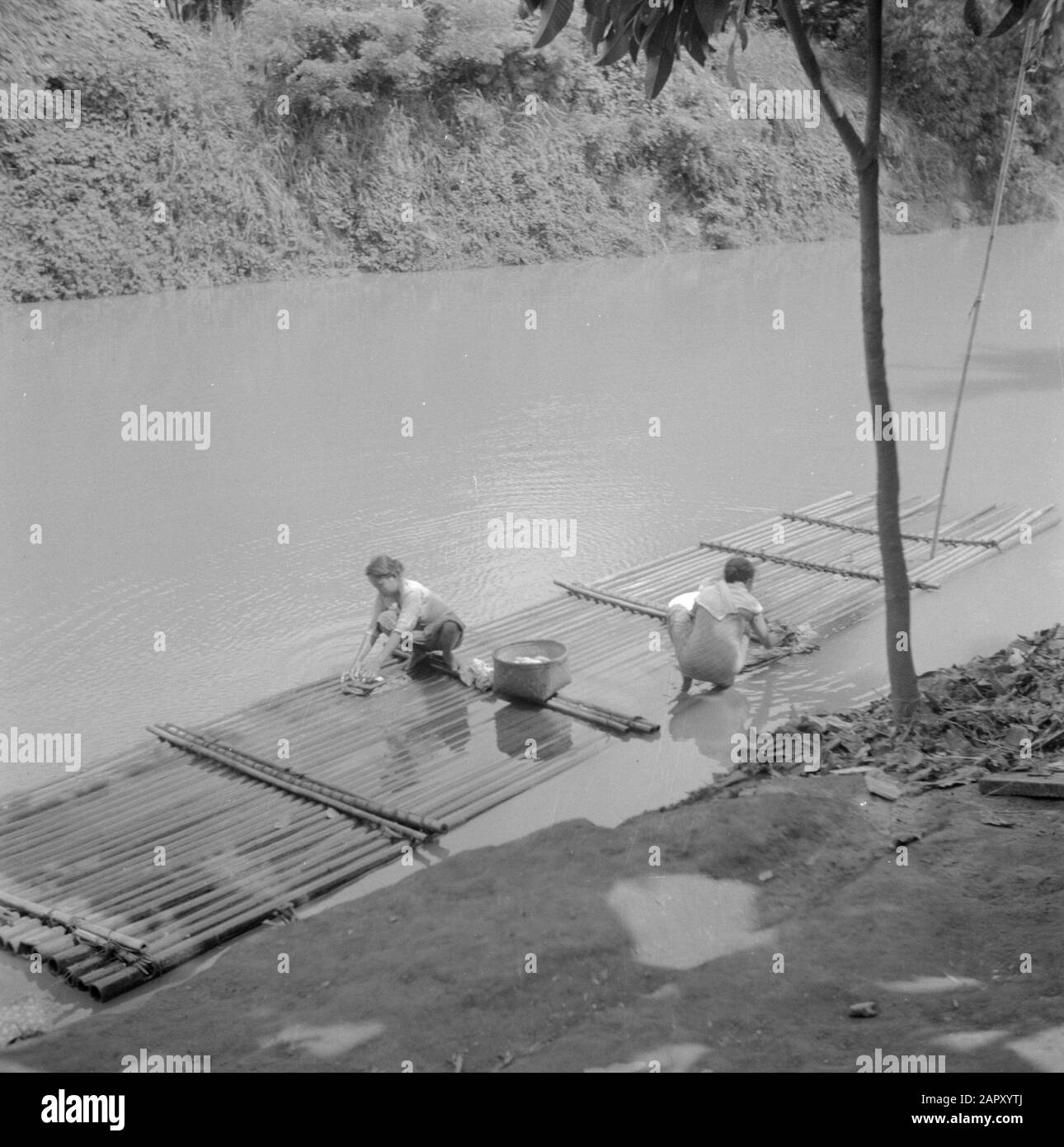 Journey to Indonesia Women doing the laundry on a bamboo raft in the ...