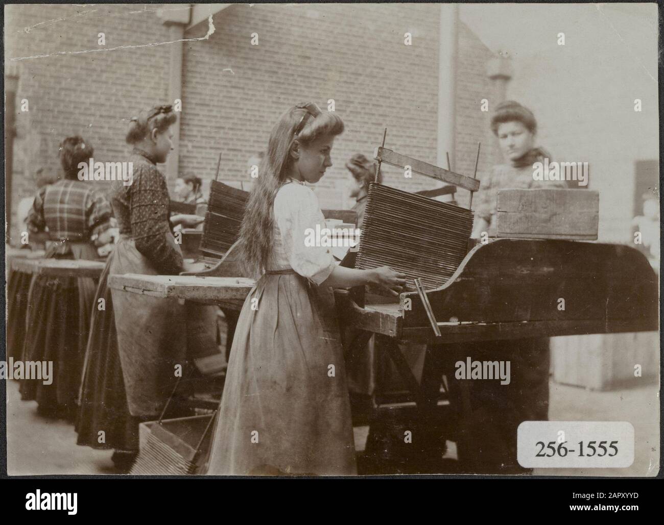 Women and girls pasting matchboxes in a match factory in Woensel Date ...