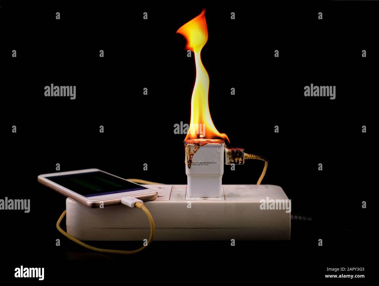On fire adapter charger mobile at plug Receptacle on black background ...