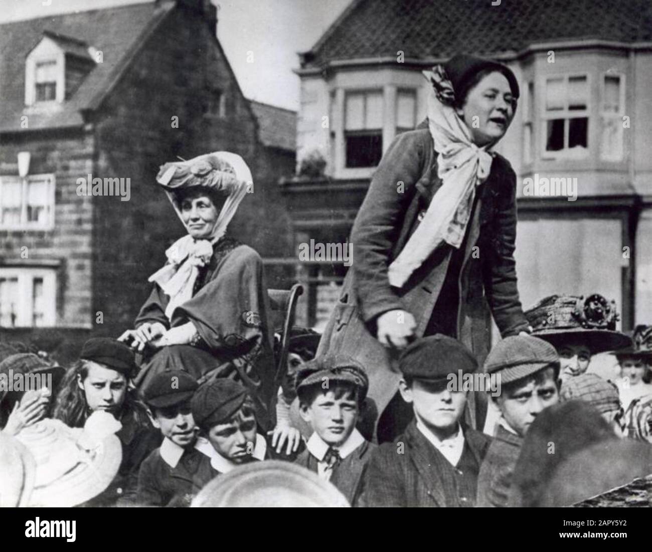 Two suffragettes are on a cart. These women were militant advocates of ...
