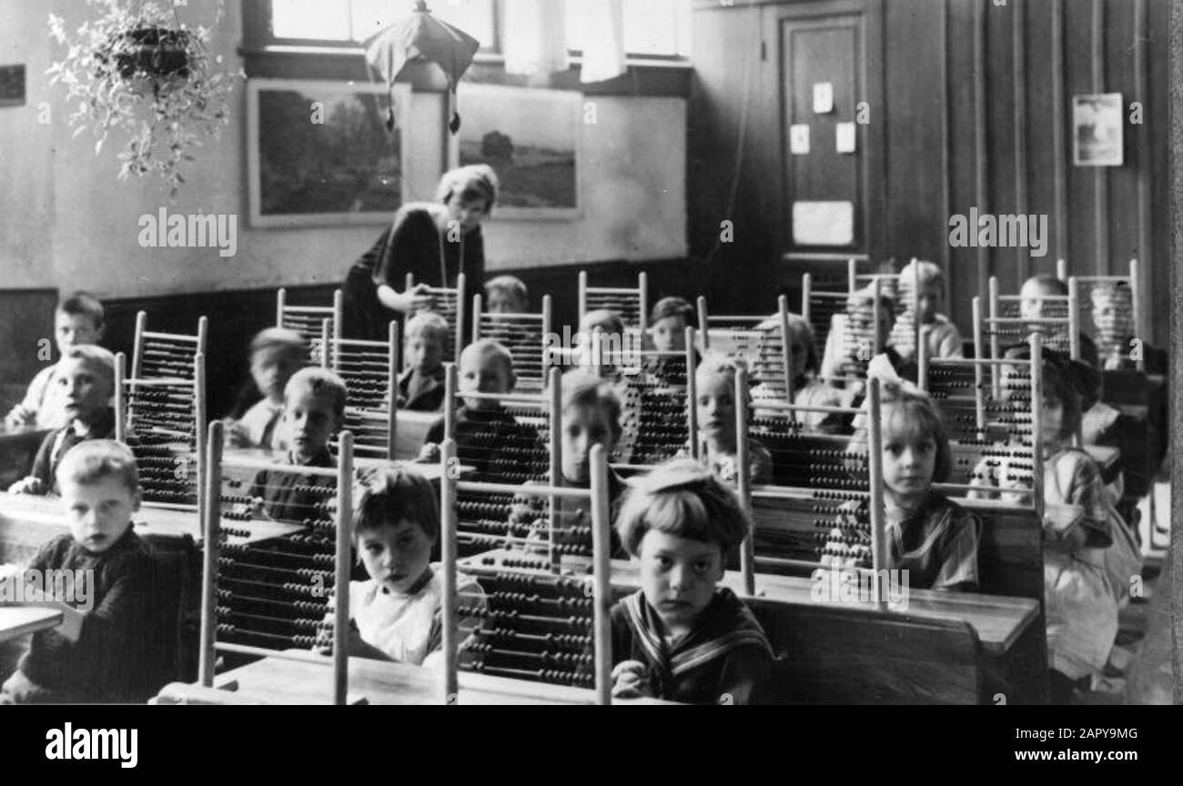 School class poses with hands folded together and frames on the table ...