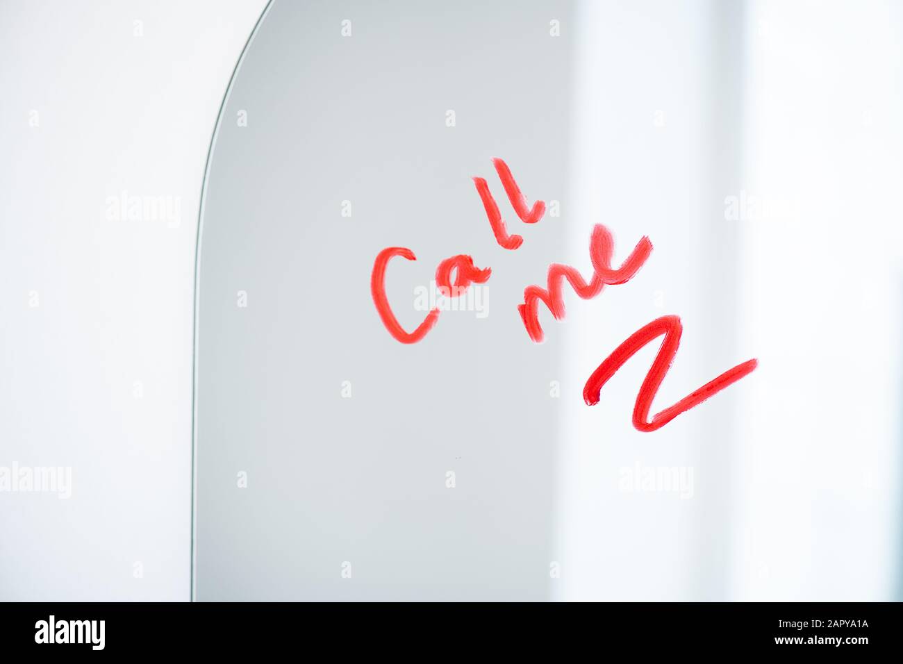 Part of mirror with asking for call written with red or crimson ...