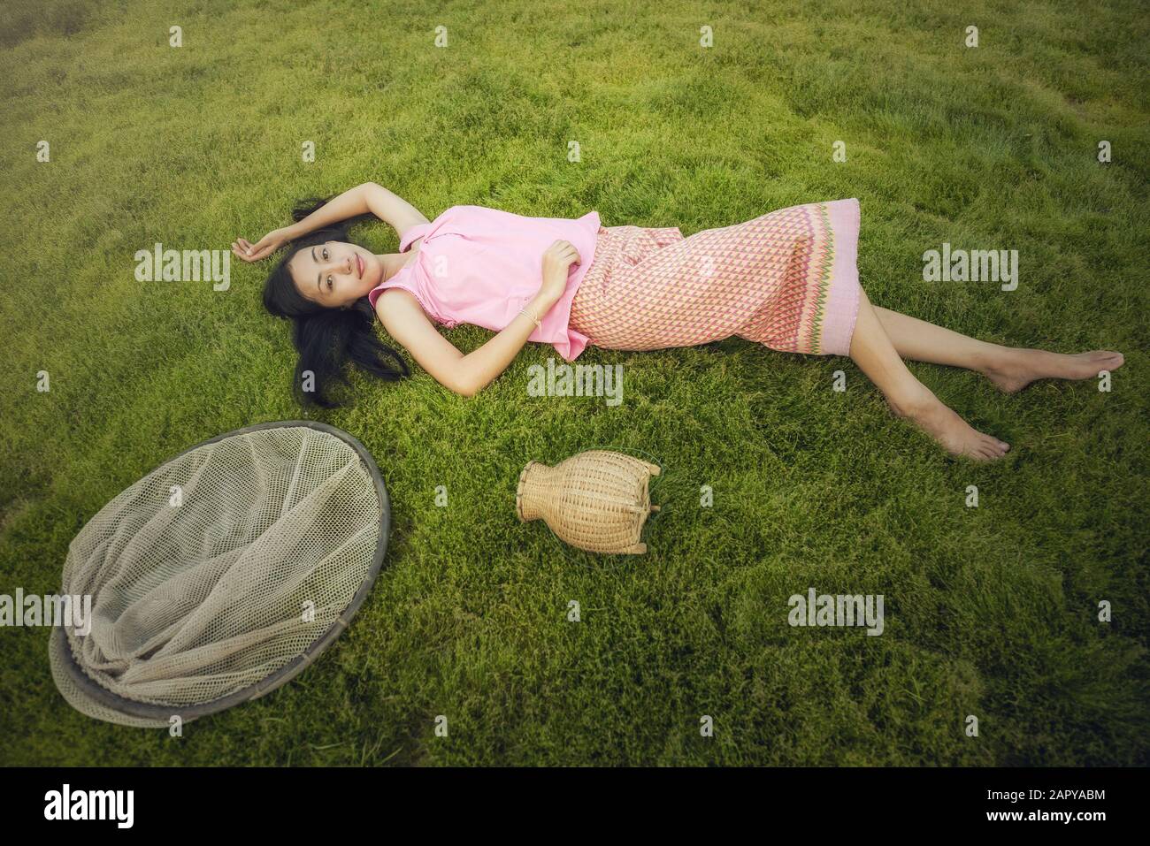 Beautiful Young Woman lying on the field in grass Outdoors Stock Photo ...