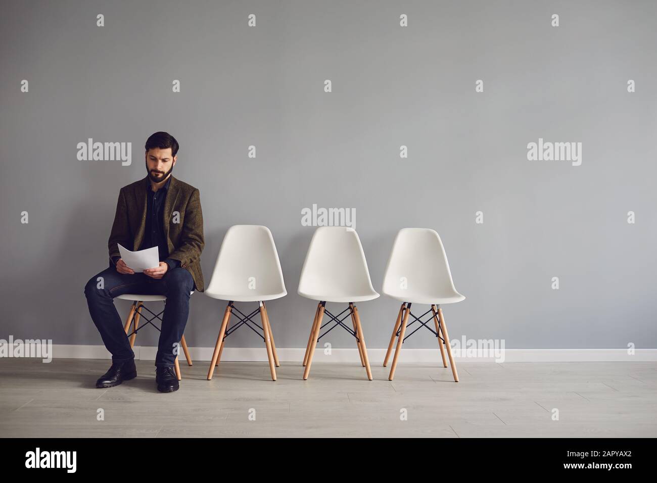 Worker awaits interview sitting on a chair in the room Stock Photo - Alamy