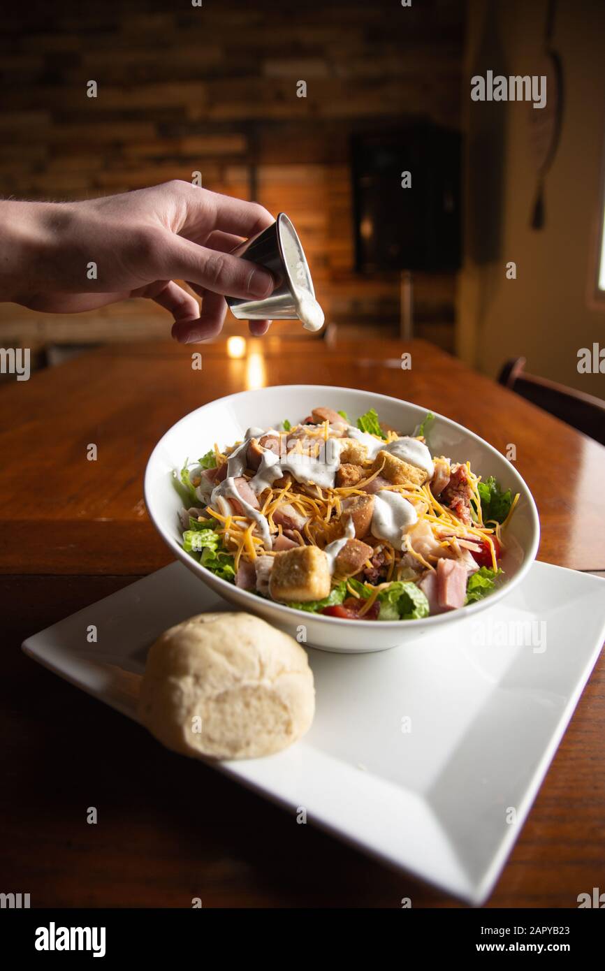 Ham salad with a roll and ranch. Ranch pouring into salad Stock Photo ...
