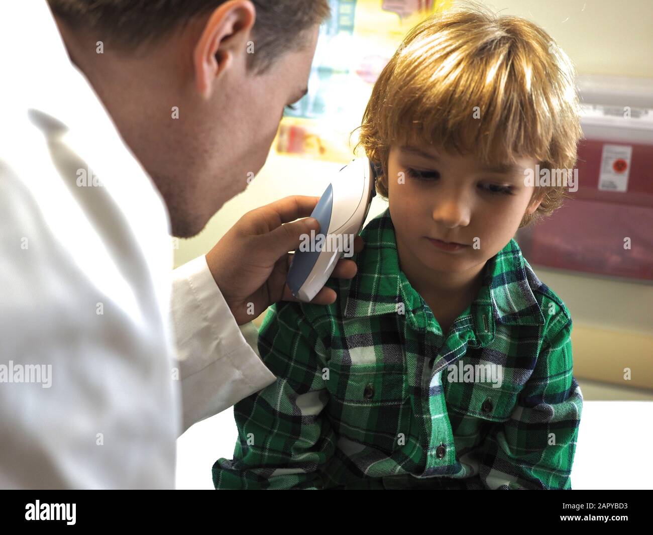 Doctor checking a child's temperature at a hospital Stock Photo - Alamy