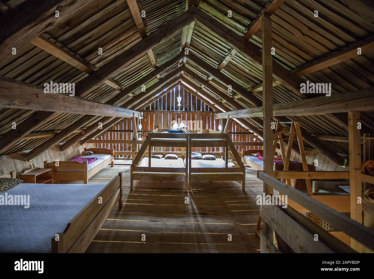 Room with many beds in the roof of a house with wooden walls Stock ...