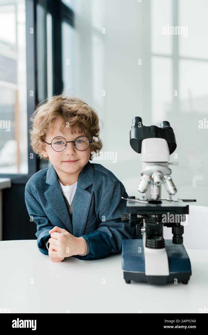 Cute little scientist in eyeglasses and formalwear standing by ...
