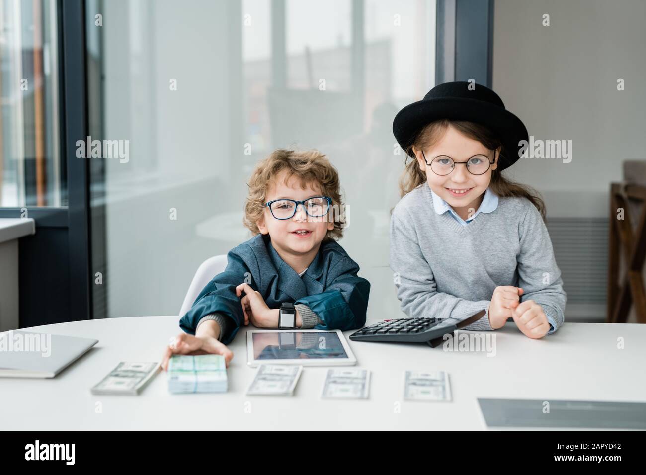 Two cute little accountants looking at you while counting and giving ...