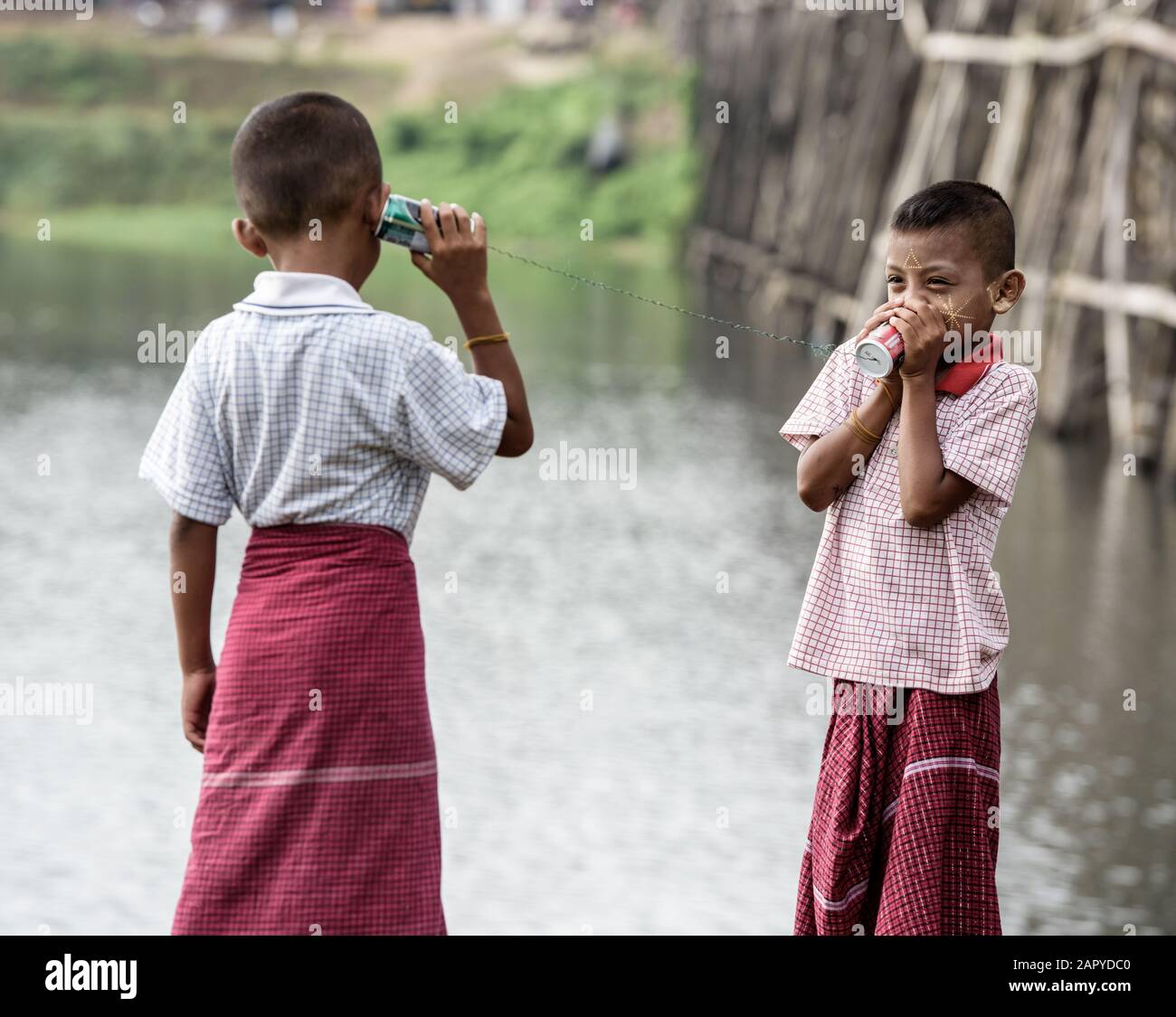 Asian boys talking on a can phone Stock Photo - Alamy