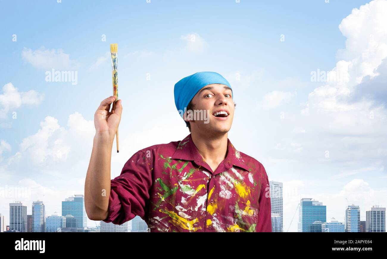 Smiling young painter artist pointing upwards Stock Photo - Alamy