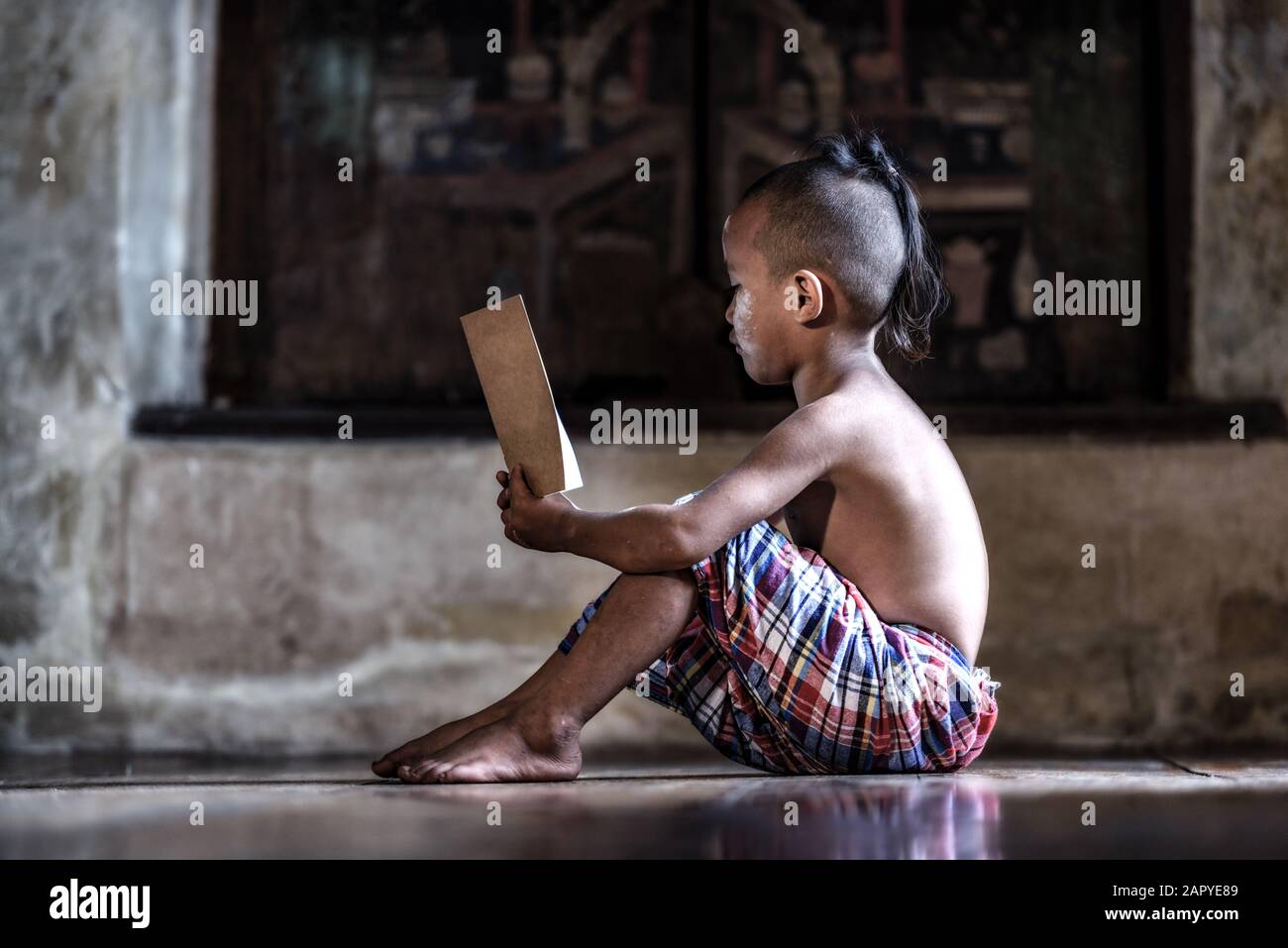 Asian boy reading book Stock Photo - Alamy