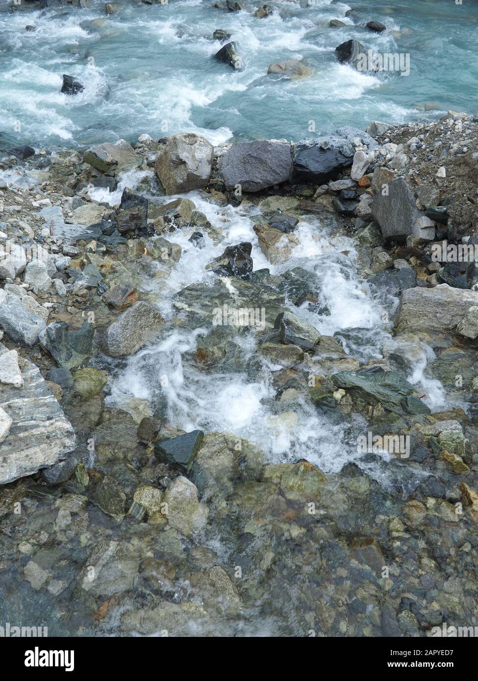 Vertical shot of rocks in a stream flowing water Stock Photo - Alamy