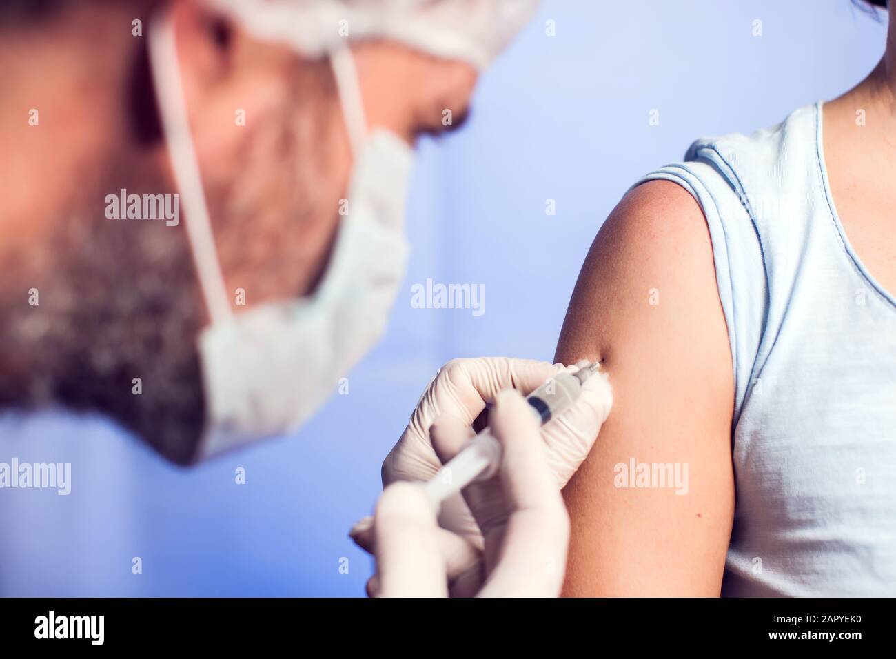 A doctor doing injection to the patient in medical office. Isolated ...