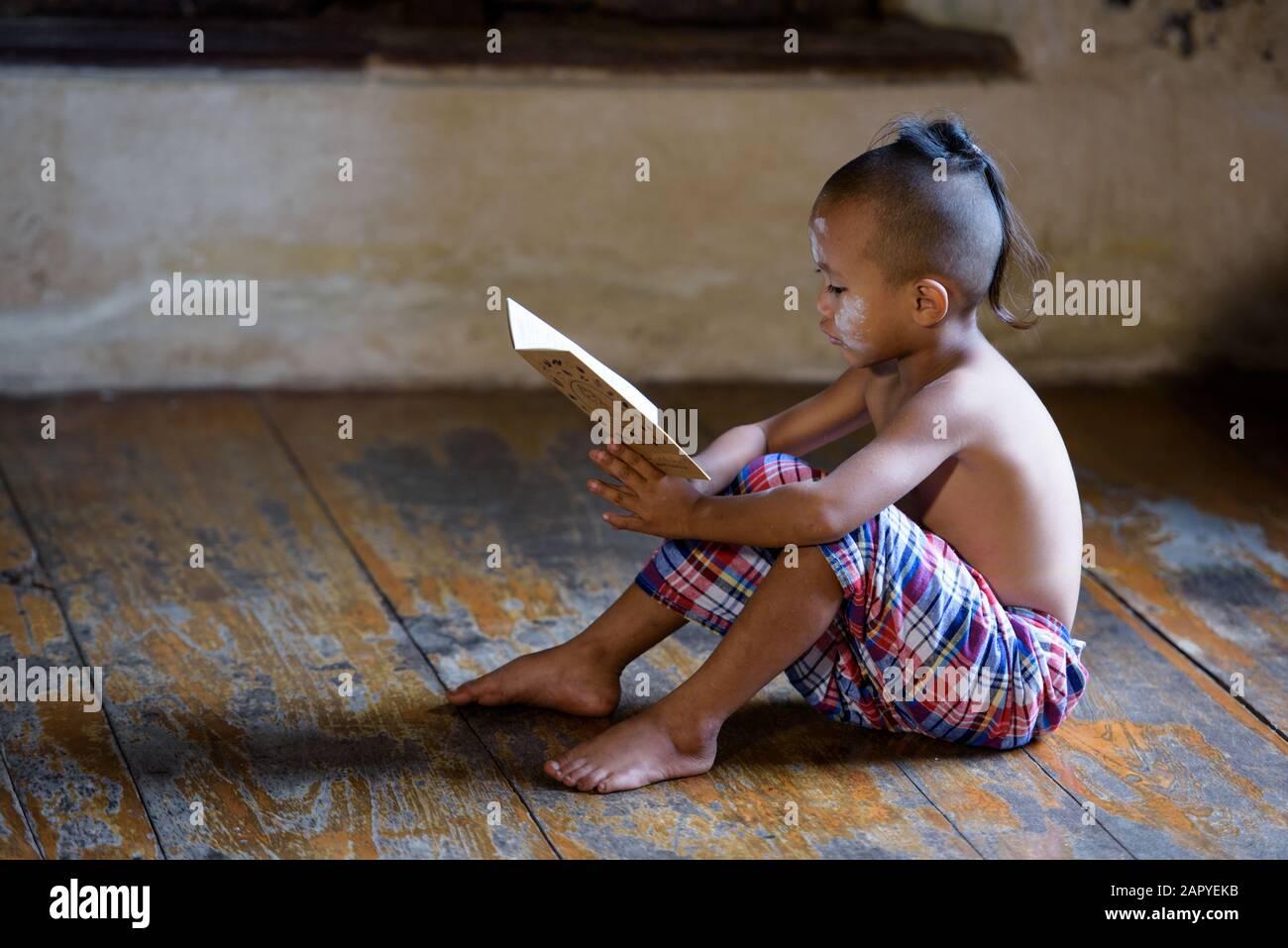 Asian boy reading book Stock Photo - Alamy