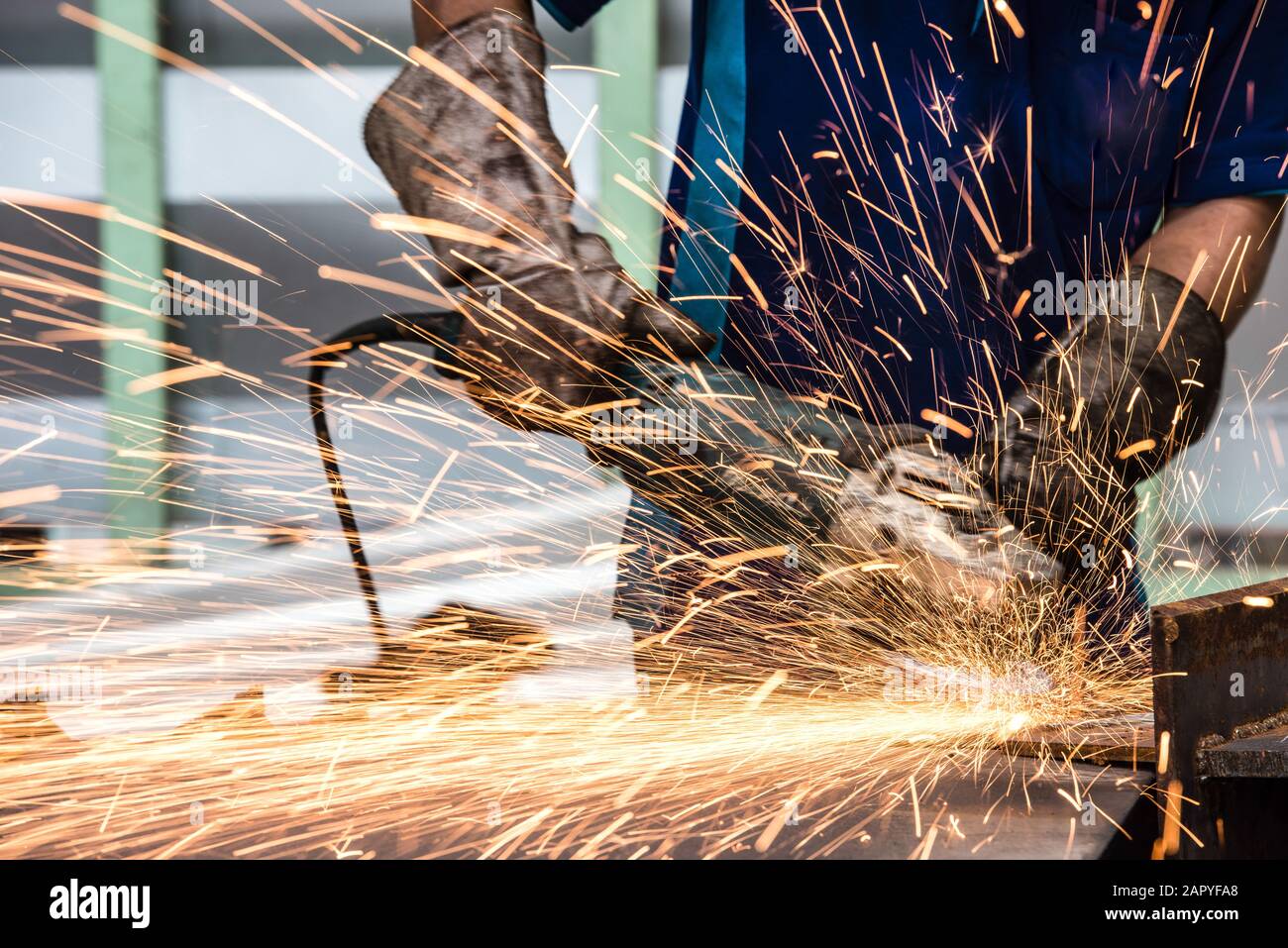 Electric wheel grinding on steel structure in factory Stock Photo - Alamy