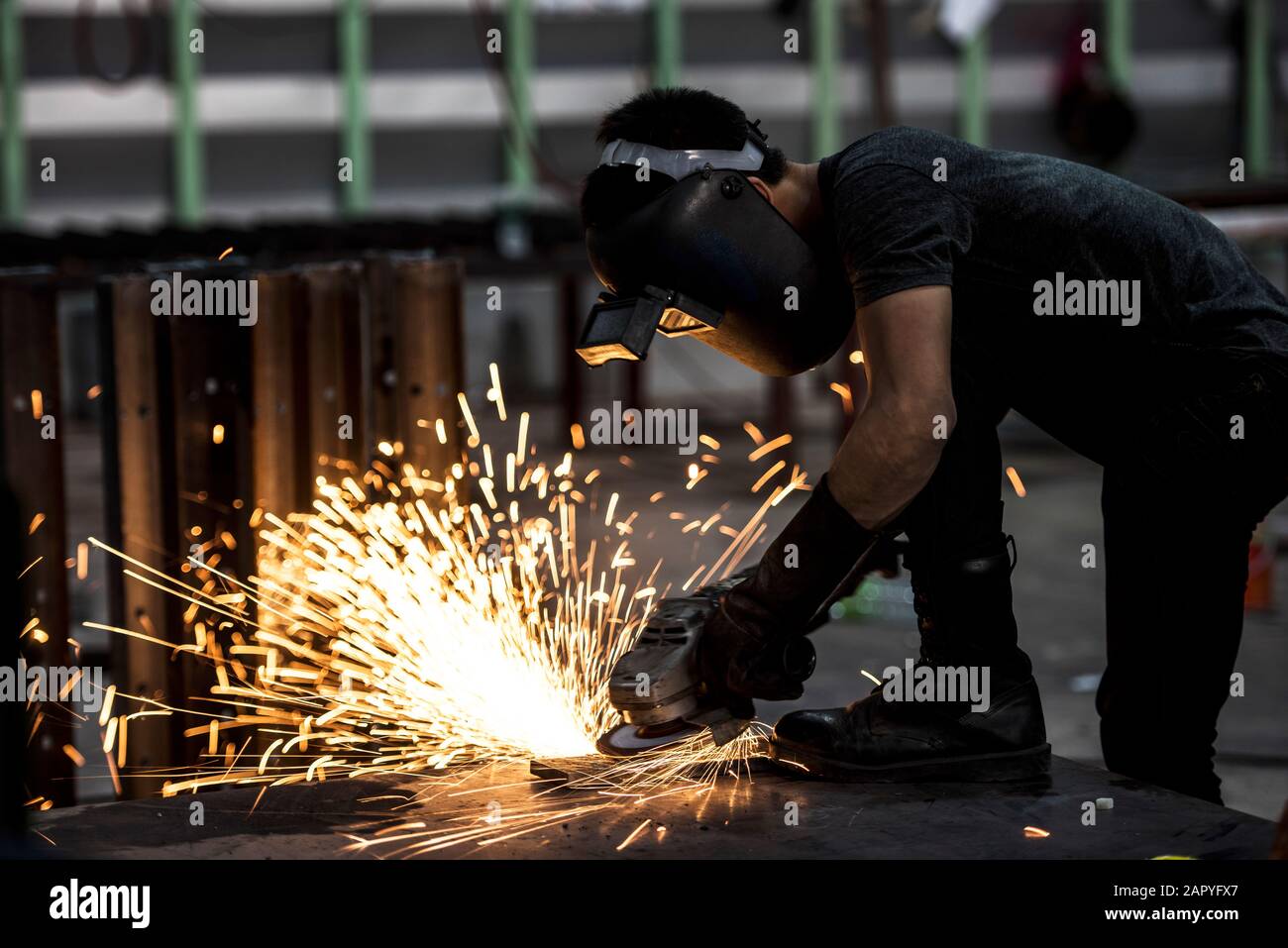 Electric wheel grinding on steel structure in factory Stock Photo - Alamy