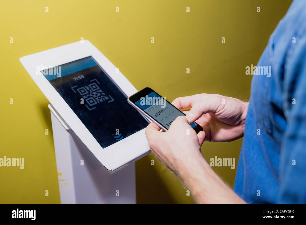Hands of young contemporary man with smartphone standing by terminal ...