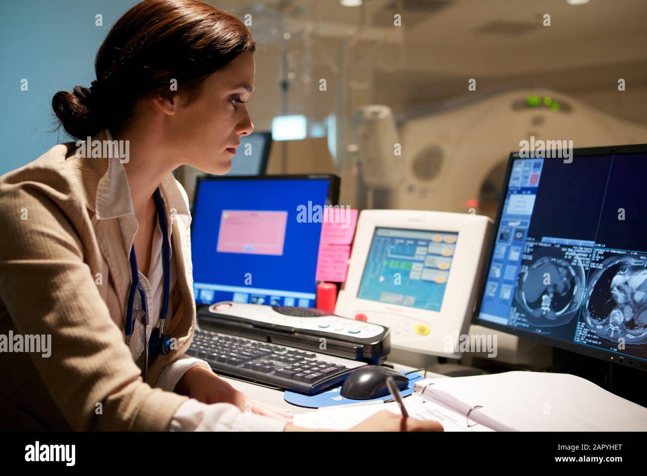 Doctor in front of computers looking at x-rays in a hospital under the ...
