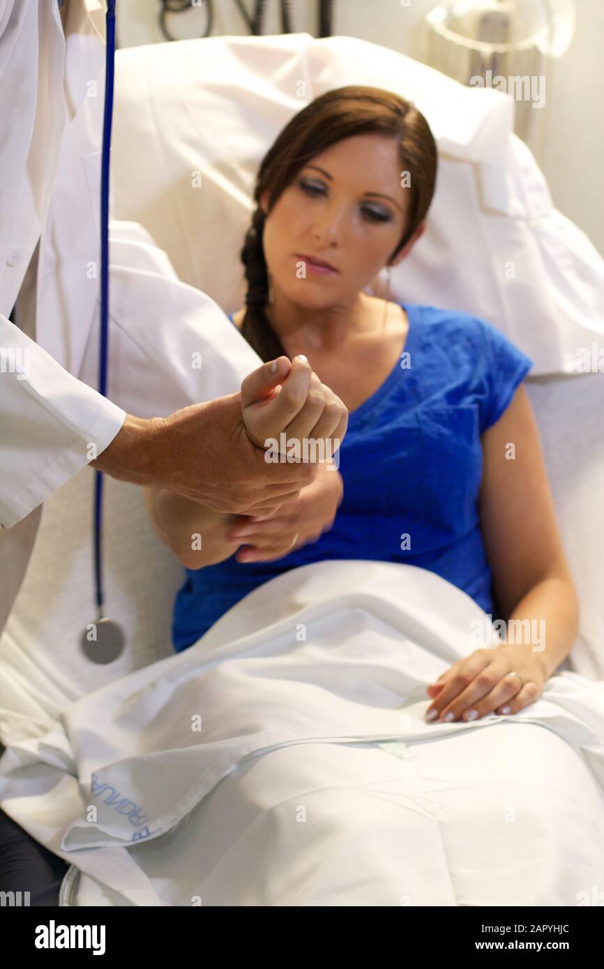 Doctor checking a patient lying in the bed under the lights in the ...