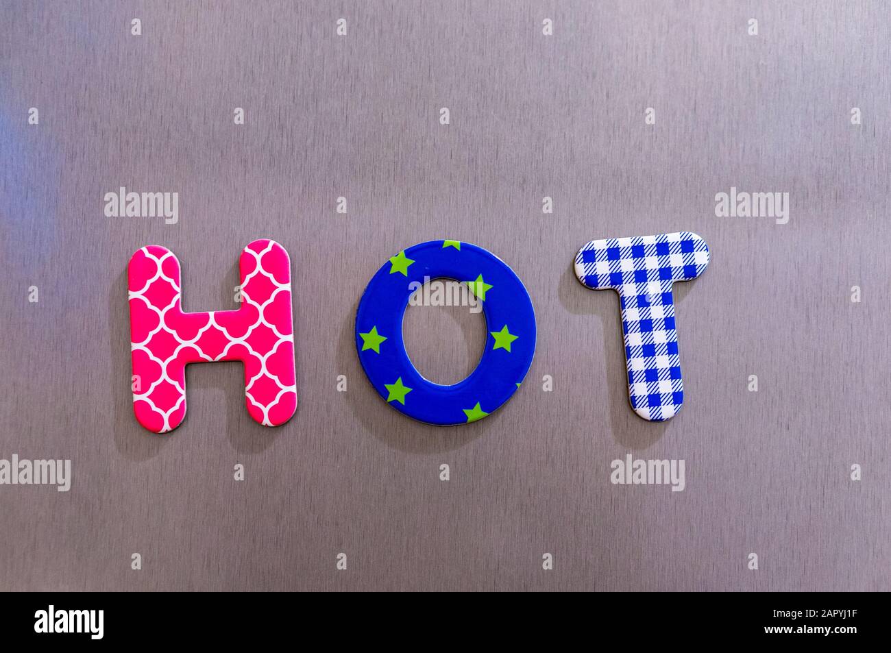 Word hot made of colorful magnetic letters on a brown background Stock ...