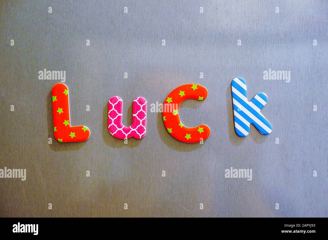 Word luck made of colorful magnetic letters on a brown background Stock ...