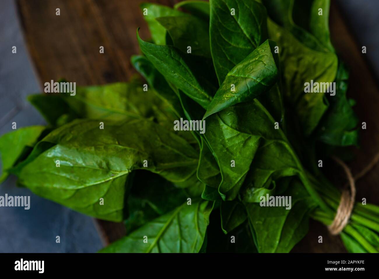 Organic food concept with bunch of fresh raw spinach herb on concrete ...