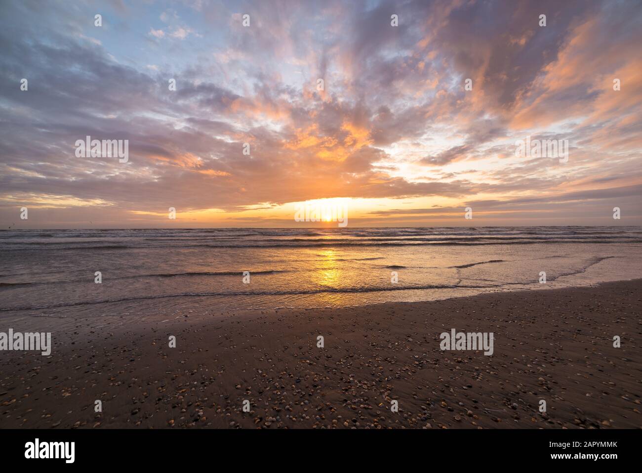 Colored clouds during sunset at the beach Stock Photo - Alamy