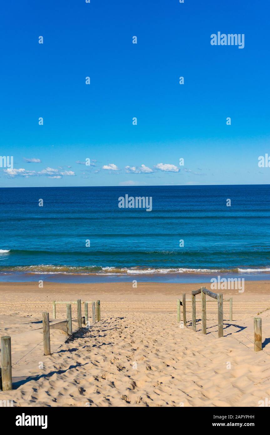 Beach entrance with wooden railings and calm sea view. Beach summer ...