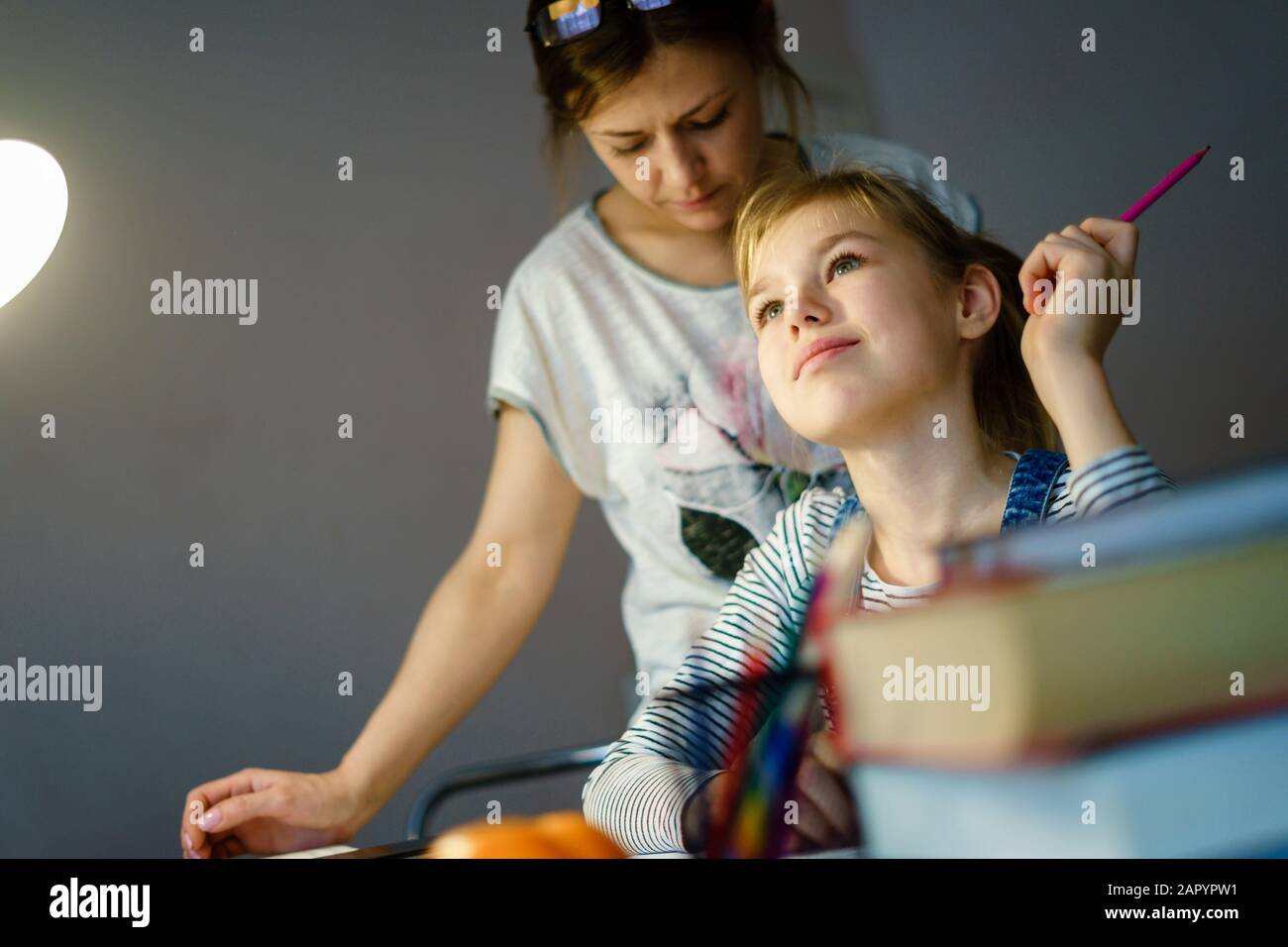 Happy Young Mother Helping Her Daughter While Studying At Home Stock ...