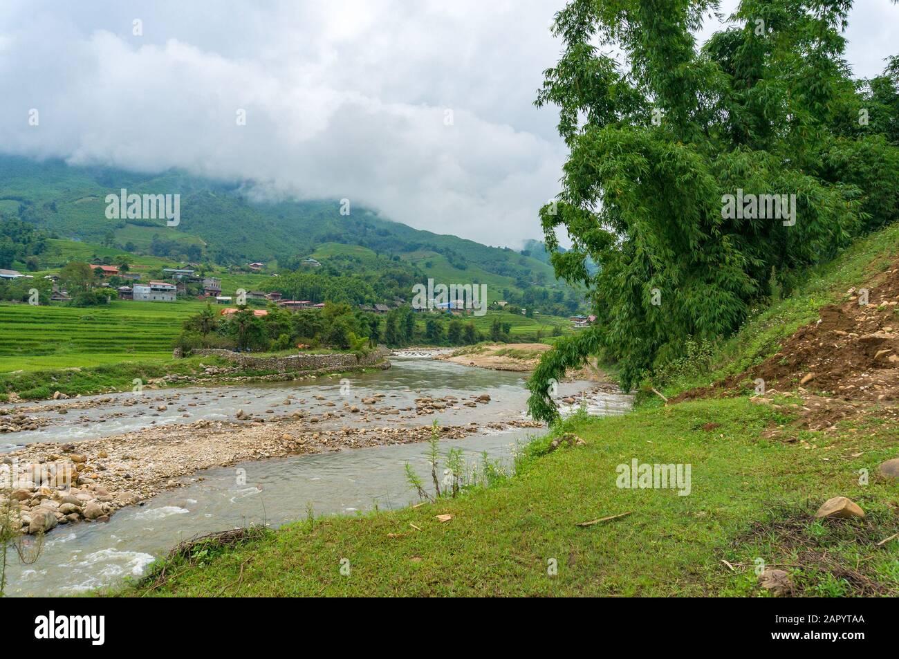 Beautiful rural landscape with river and village among rice terraces ...