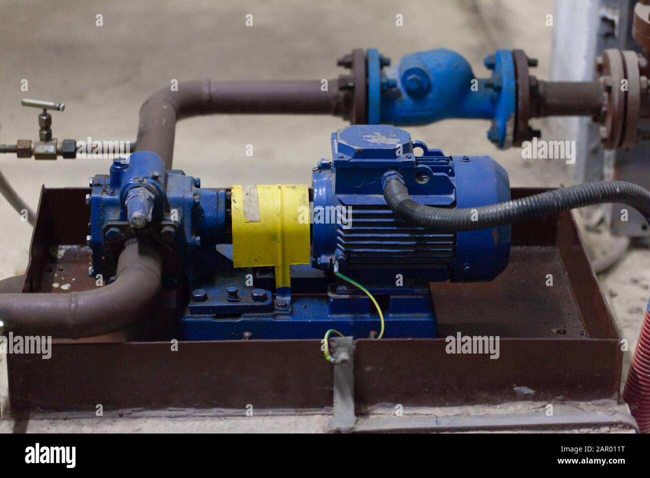The oil pump with the pipelines in the production Stock Photo - Alamy