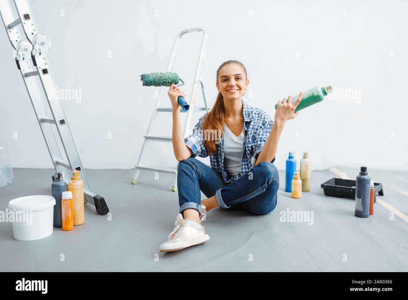 Female house painter sitting on the floor Stock Photo - Alamy
