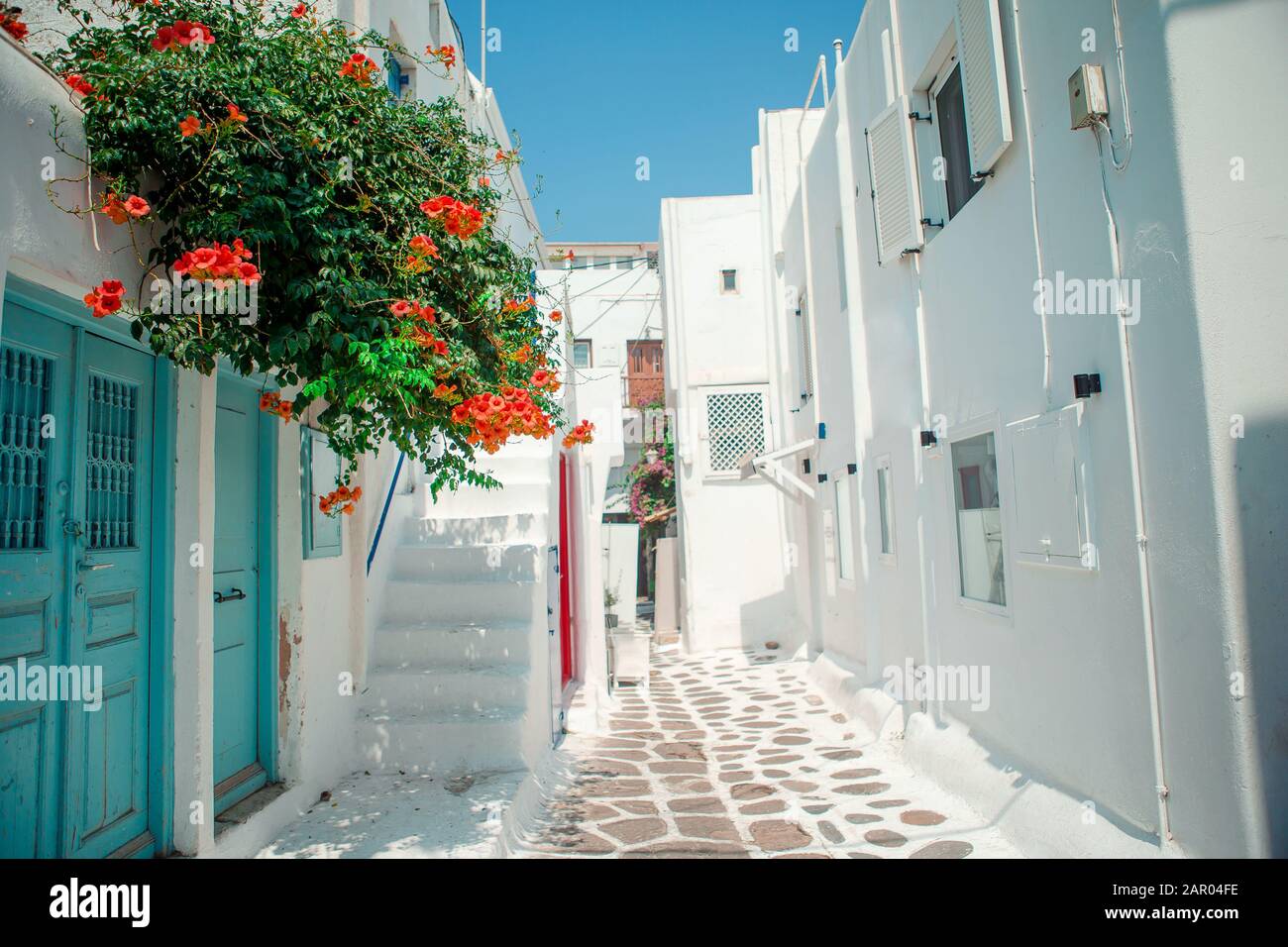 The narrow streets of greek island with blue balconies, stairs and ...