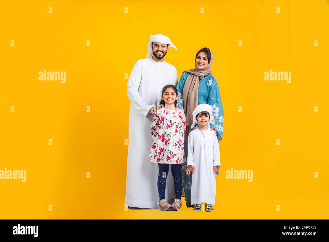 Middle eastern family with traditional emirates dresses posing in a ...