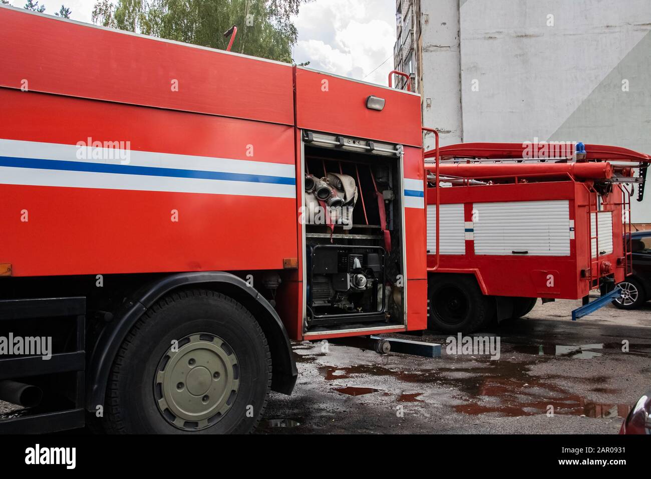 Two red fire trucks closeup near house Stock Photo - Alamy