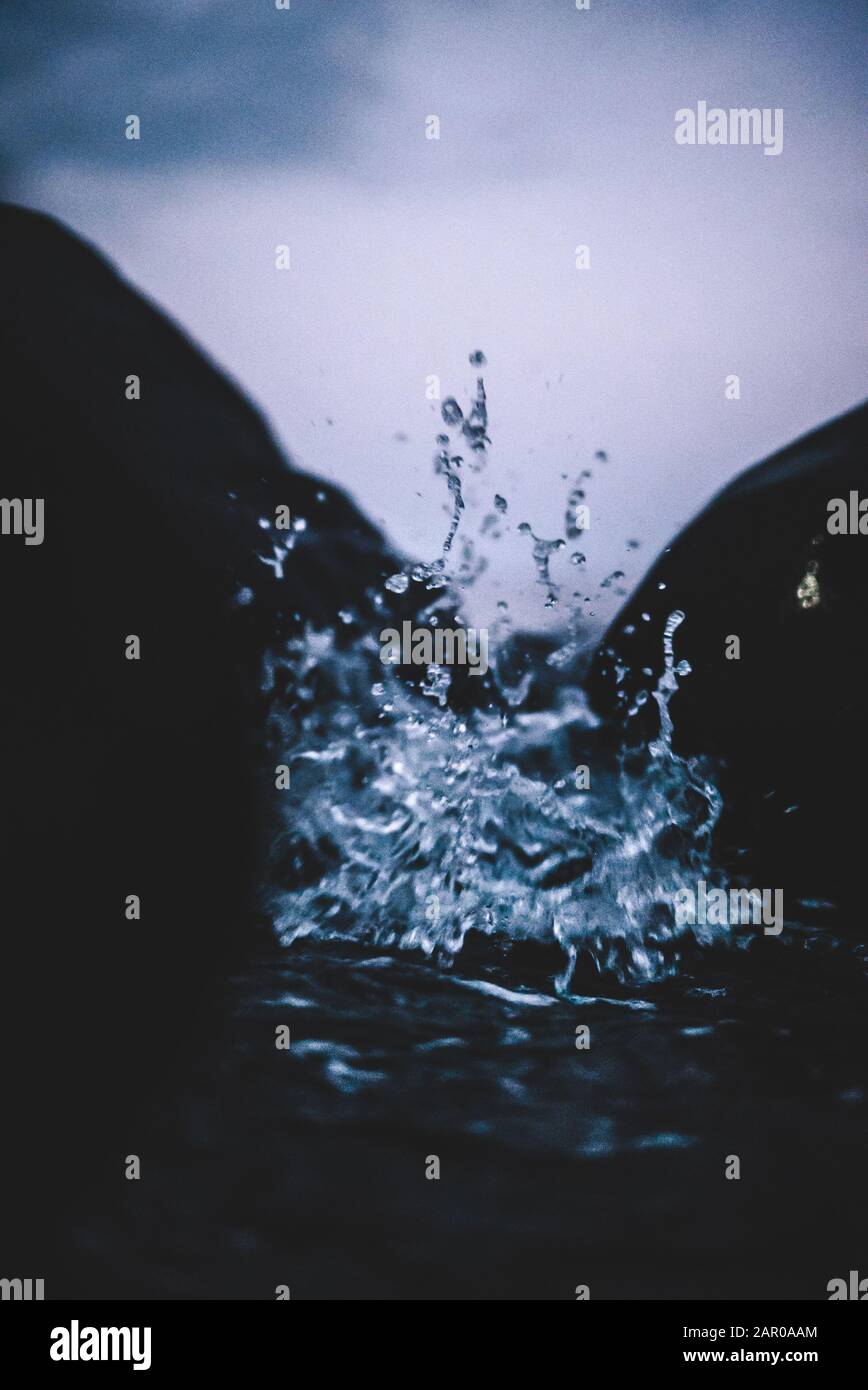 Water hitting rocks and small water drops splash into the camera Stock ...
