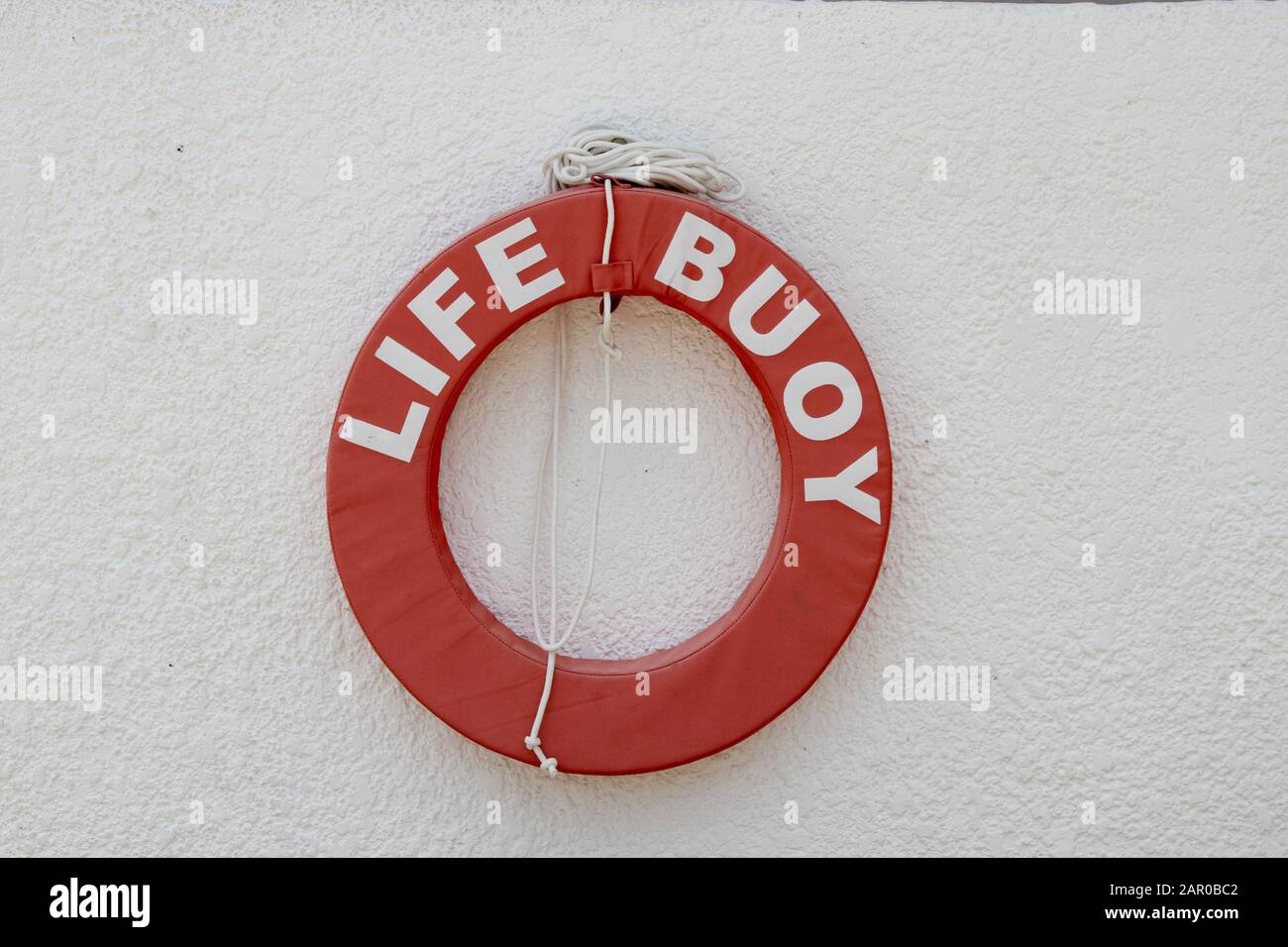 Red life buoy on white concrete brick wall, Mauritius Stock Photo - Alamy