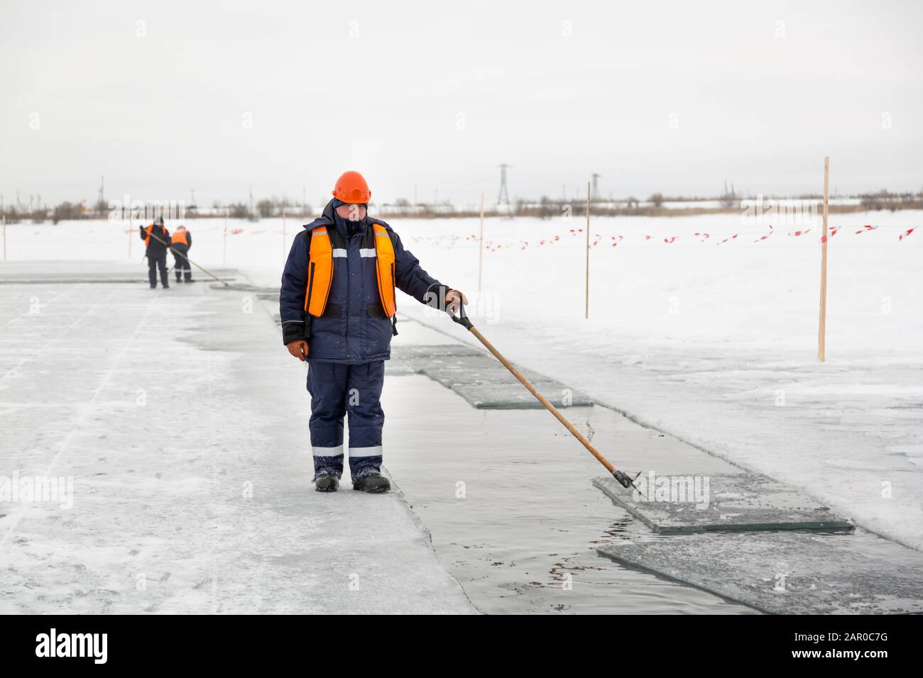 Worker rafts ice blocks along a canal carved in a frozen lake Stock ...