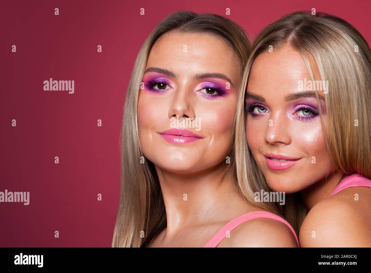 Beautiful smiling women models with makeup on pink Stock Photo - Alamy