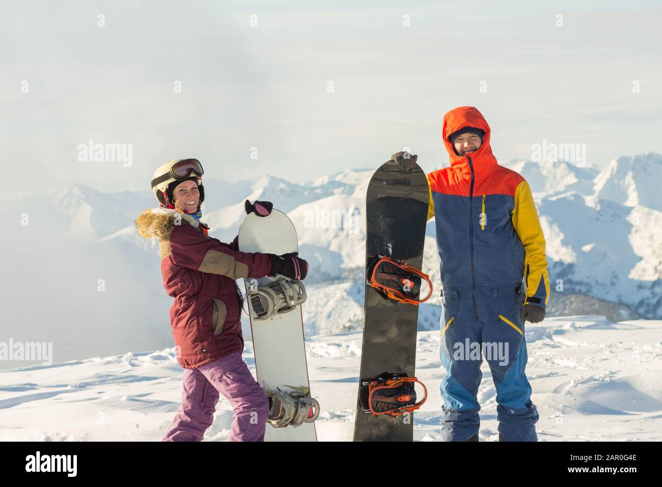 Couple snowboarding freeriders man and a woman stand on the background ...